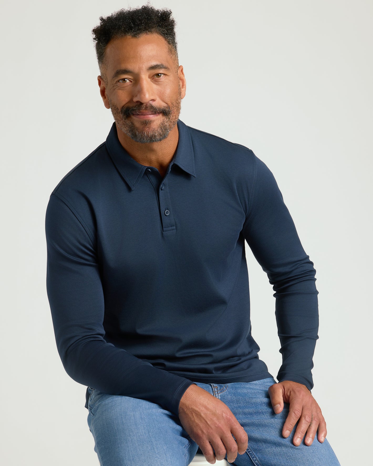 Man wearing Core Premium Pima Long Sleeve Polo, showcasing its fit.